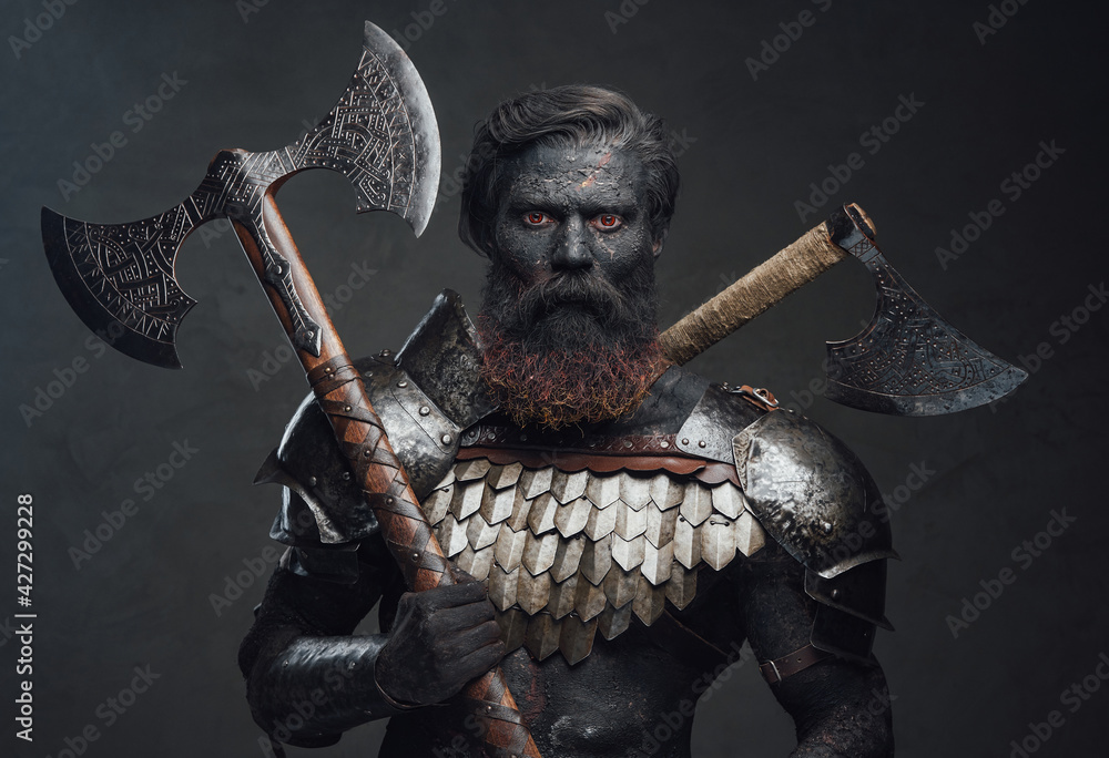 Fearful and muscular warrior with scorched skin and double axe Stock ...