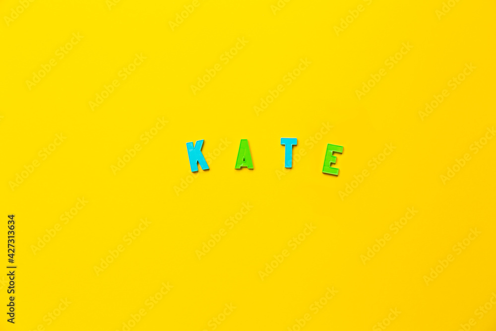 The word Kate made of colored plastic letters with magnets on a yellow ...