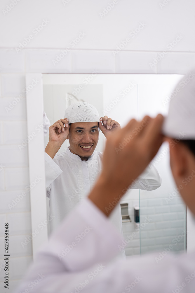 muslim asian man looking at mirror and get dressed before going to the ...