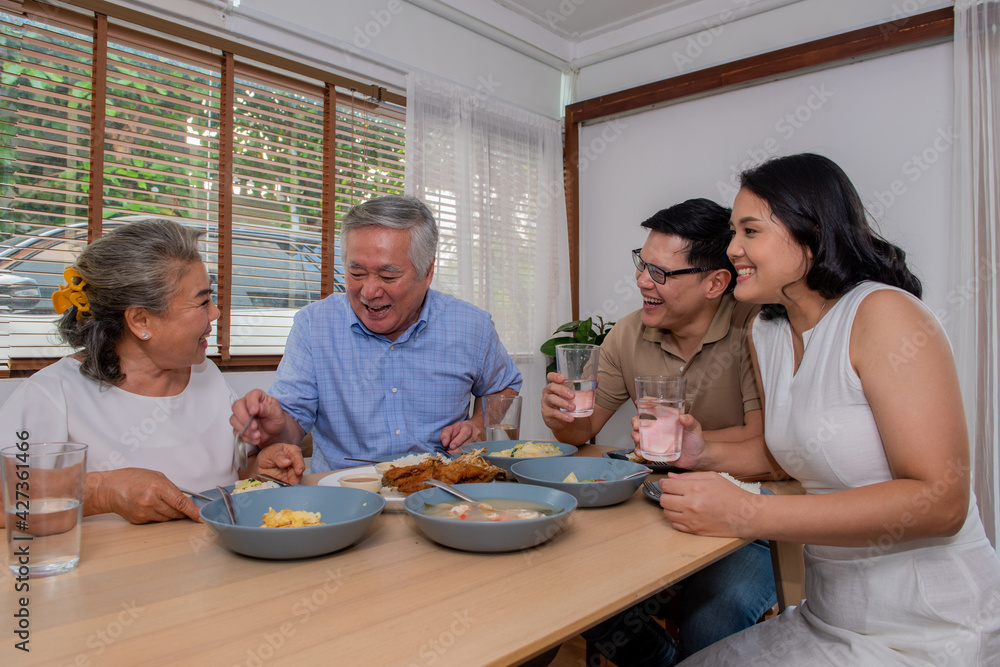 Asian family having dinner together at home. Smiling adult couple with ...