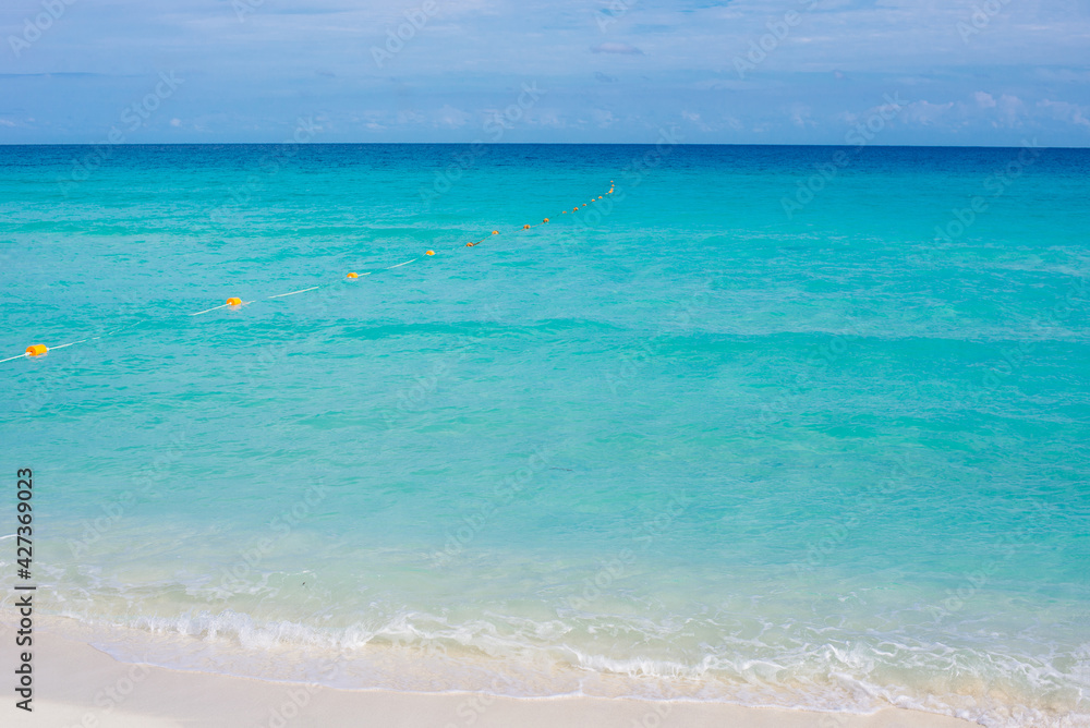 White and red round marker buoys rope floating in a sea, marking an end ...