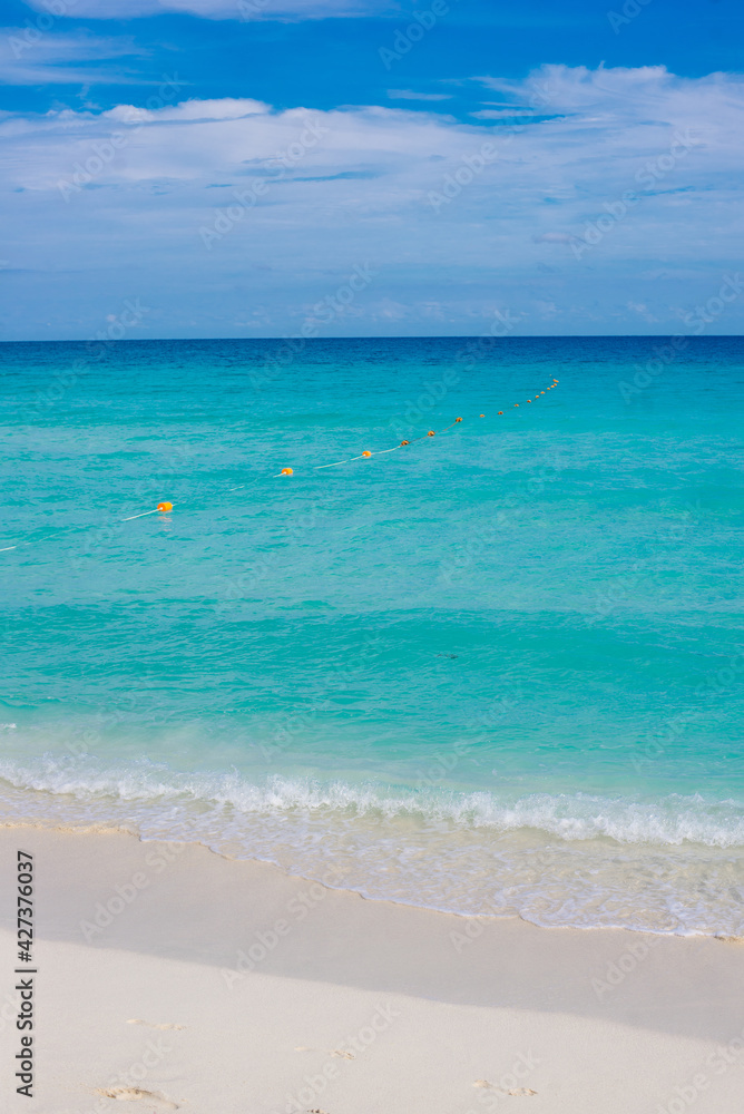 White and red round marker buoys rope floating in a sea, marking an end ...