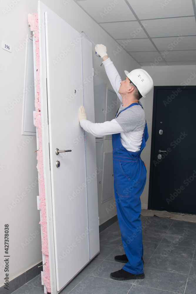installation wizard, measures the height of the door with a tape ...