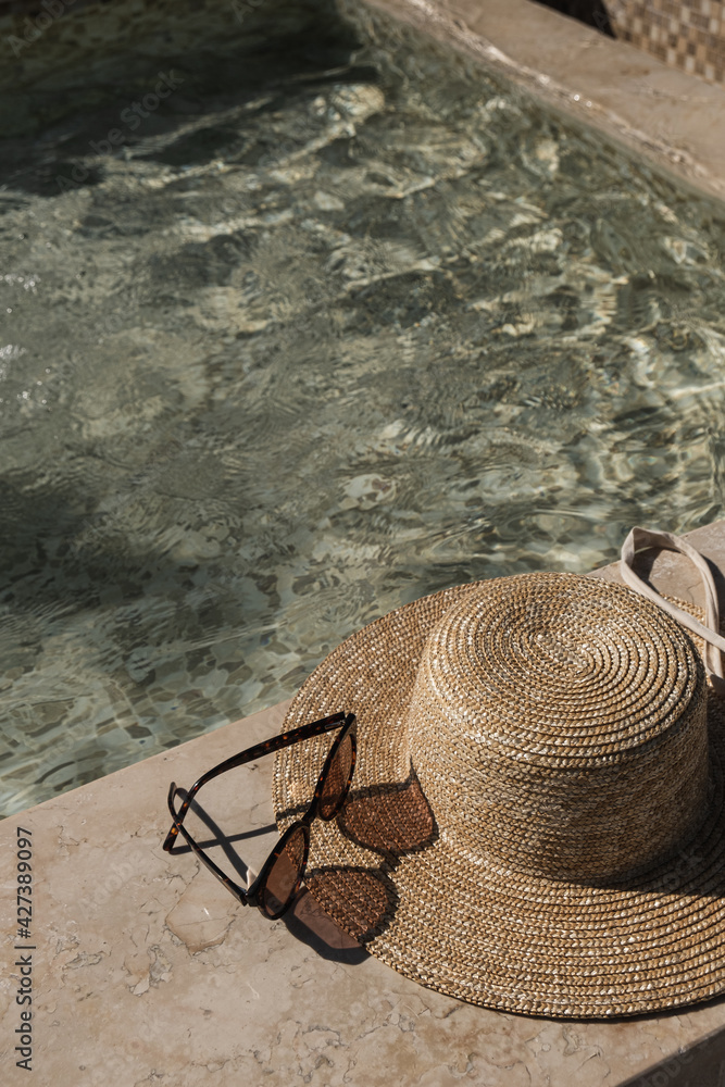 Zdjęcie Stock: Sunglasses and straw hat on marble swimming pool side ...