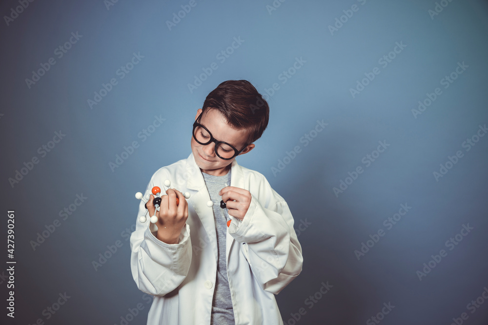 cool young boy is dressed as scientist with white lab coat and holding ...