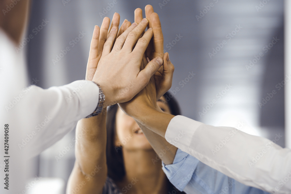 Group of business people joining hands or giving five to each other ...