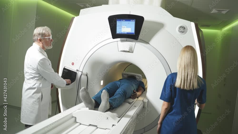 Medical technical assistant performing radiological scan of patient ...