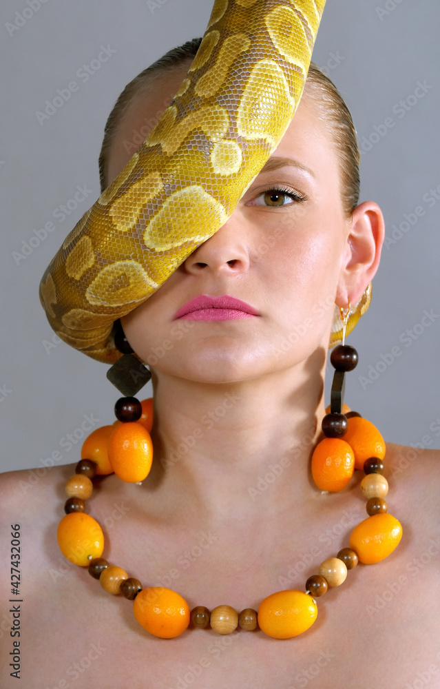 A beautiful young model poses nude for the camera. Her earrings and ...