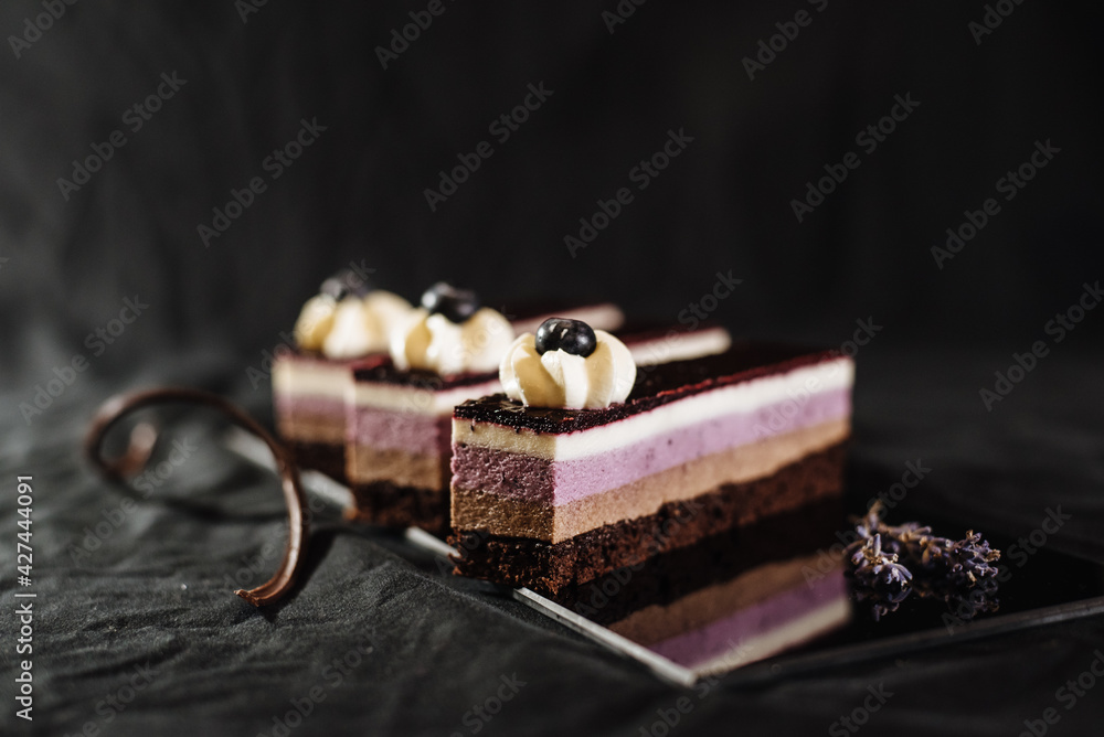 Three chocolate cakes on a black background. Mousse cake with ...