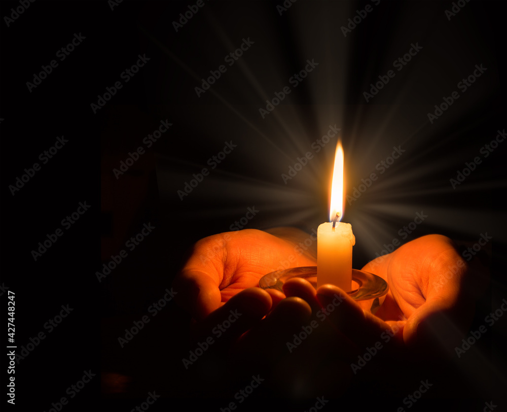 Hands holding a burning candle in dark room Stock Photo | Adobe Stock