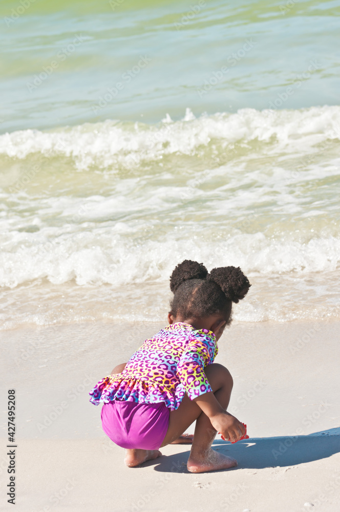 back view, medium distance of a young, black, girl in a colorful ...