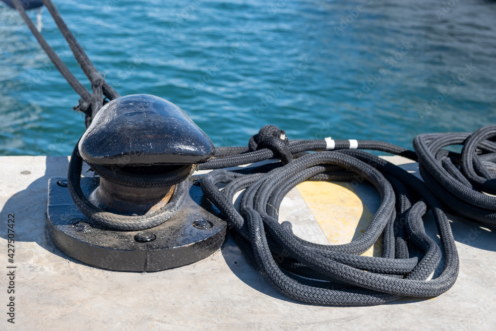 Foto de Boat ropes on black mooring bollard, luxury yachts marina pier ...