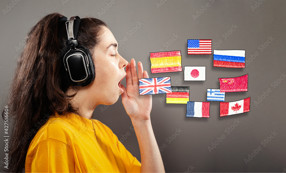 Online language learning. Portrait of a young woman wearing headphones ...