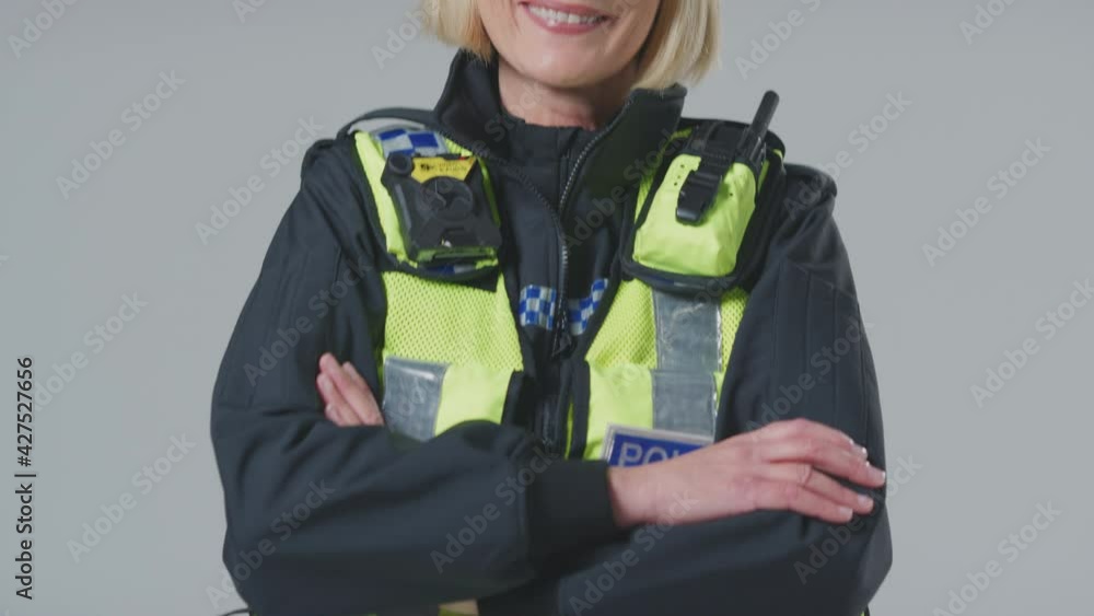 Camera tilts up to show smiling mature female police office wearing ...