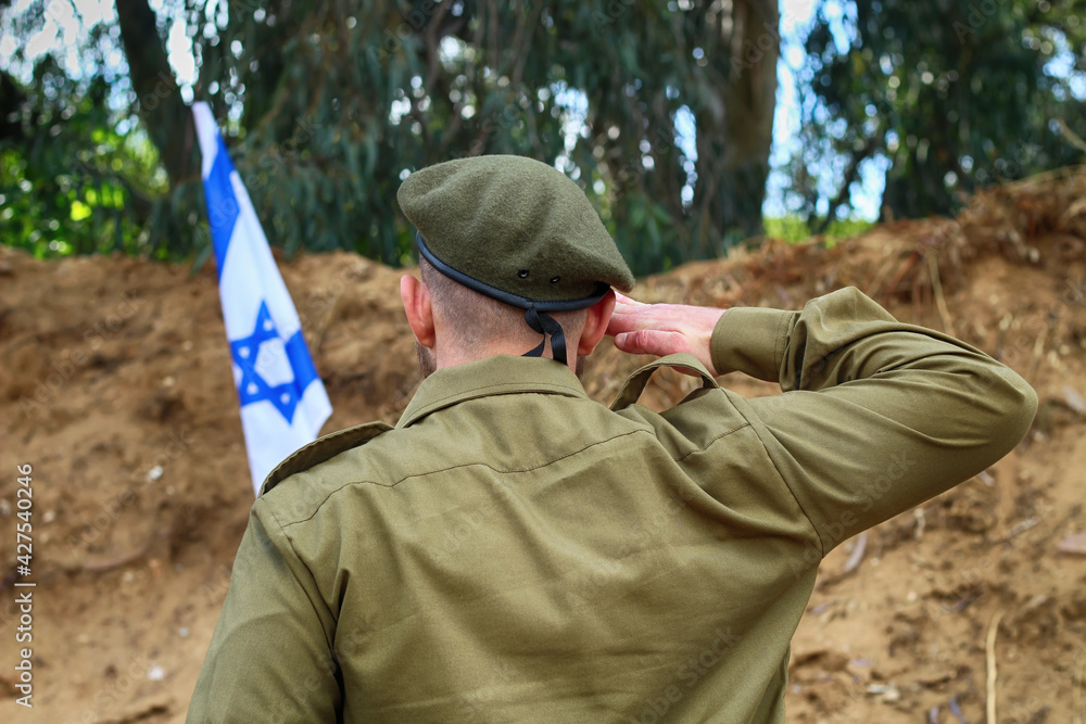 Israeli soldier salutes the Flag of Israel. Concept: Israel Remembrance ...
