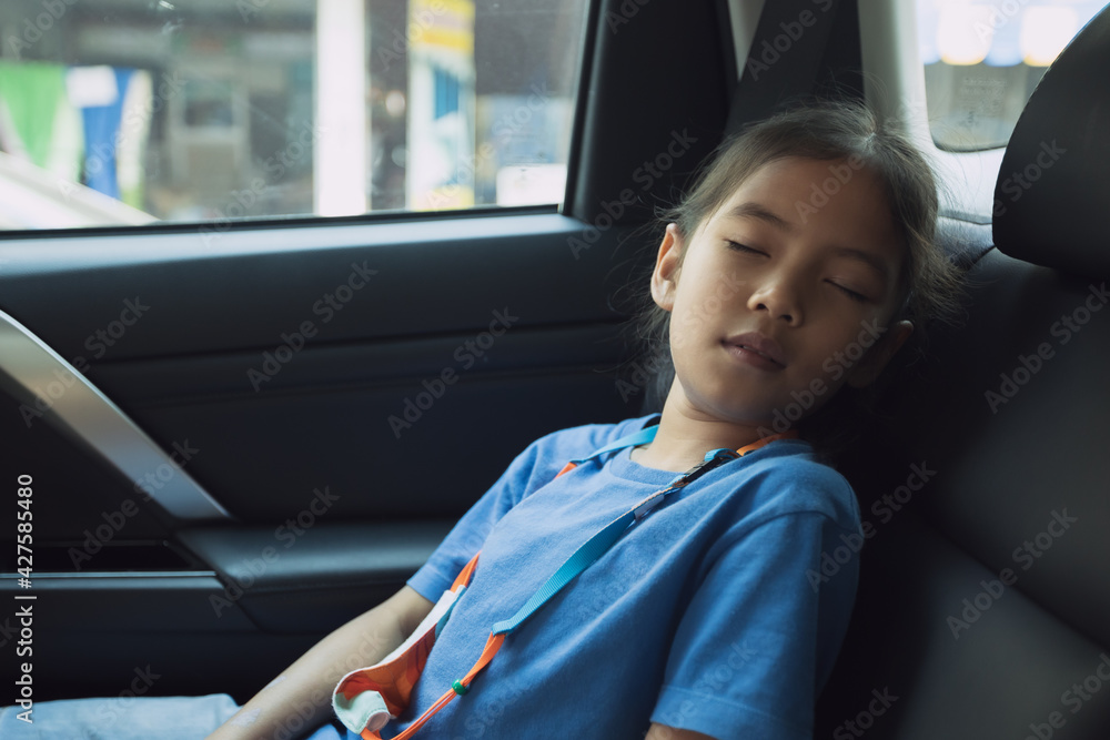Asian child girl is sleeping in the car while traveling to school ...