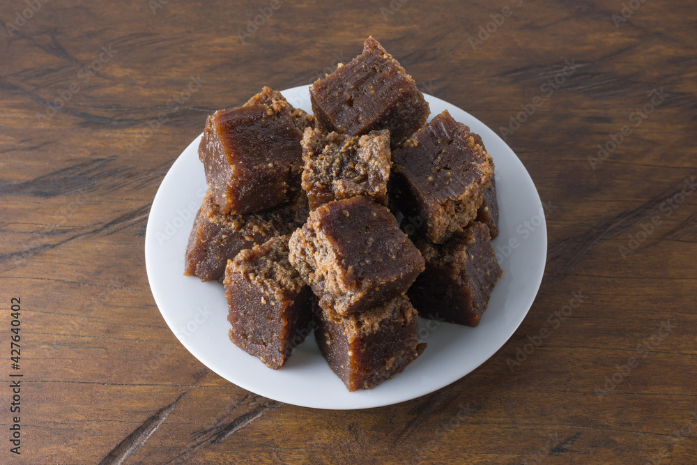 plate of dodol on a wooden table, also called kalu dodol, sri lankan ...