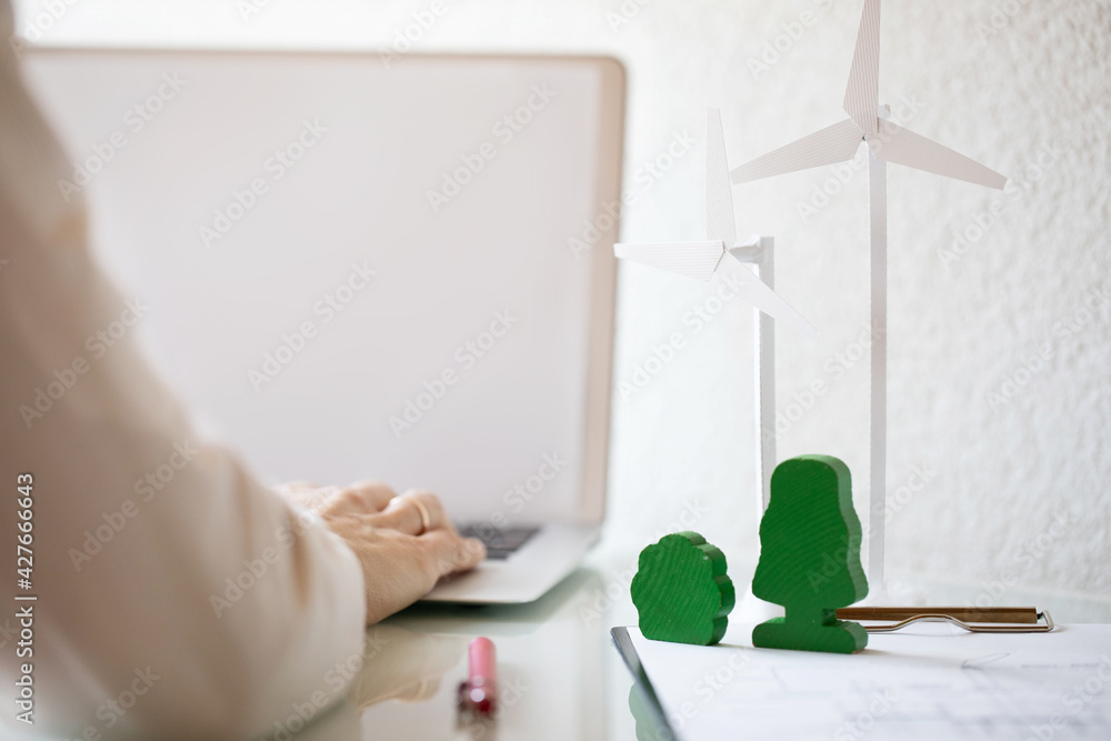 Paper model of wind turbine and model of trees on the table. Closeup ...