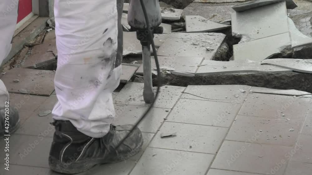 workman using pneumatic drill in construction site and house renovation ...