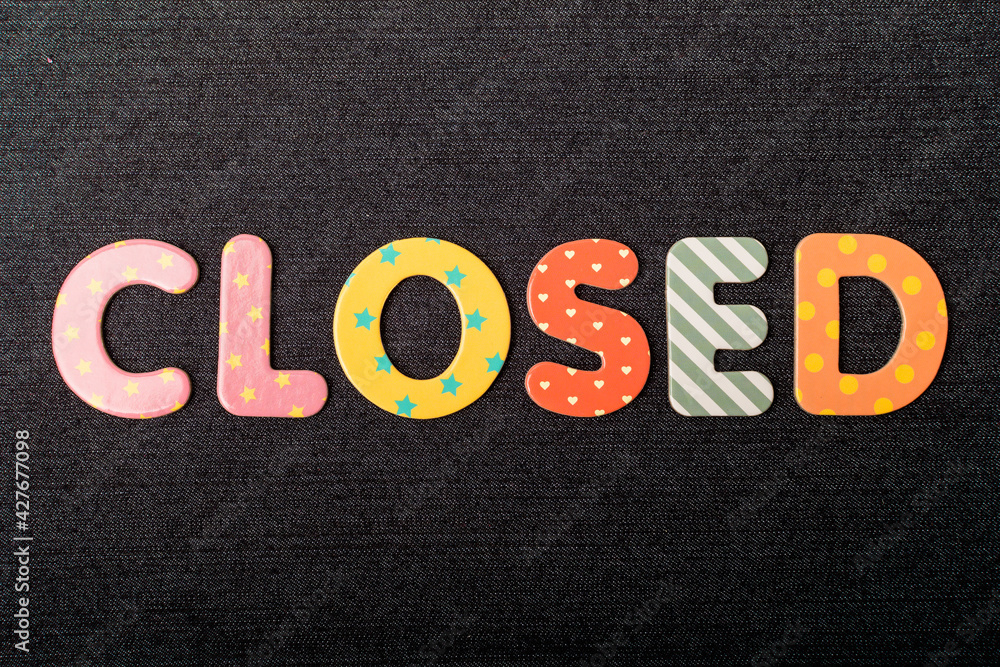 Card with Closed word made from mixed vivid colored wooden letters on a ...