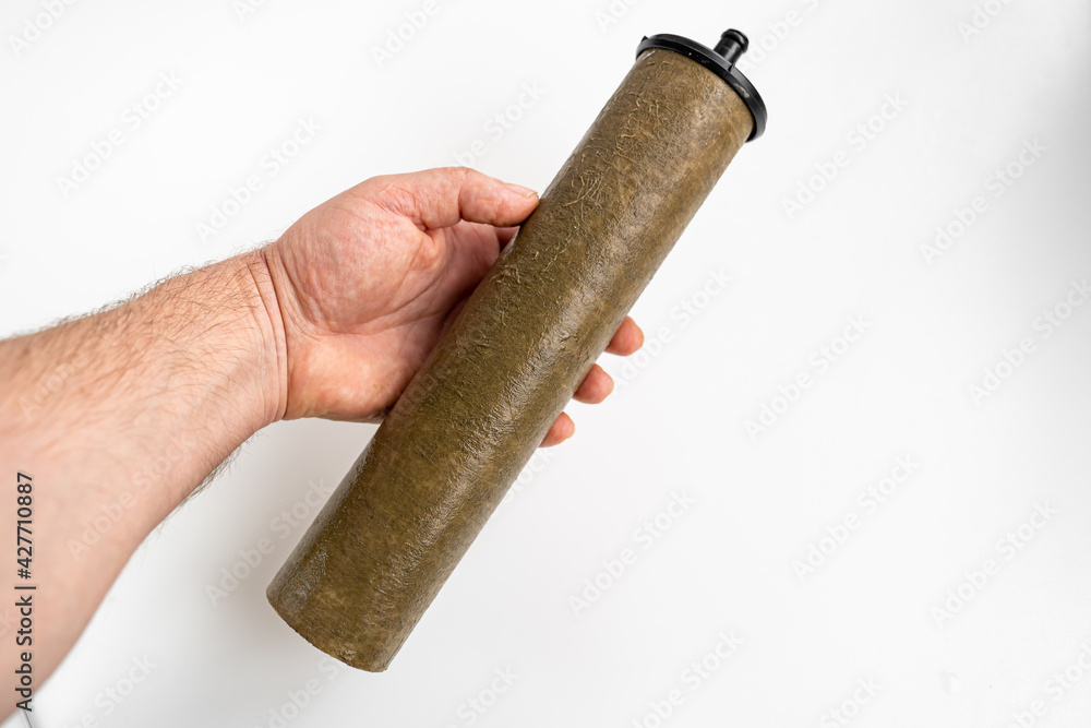 Dirty filter cartridge drinking water on a white background. Replacing ...