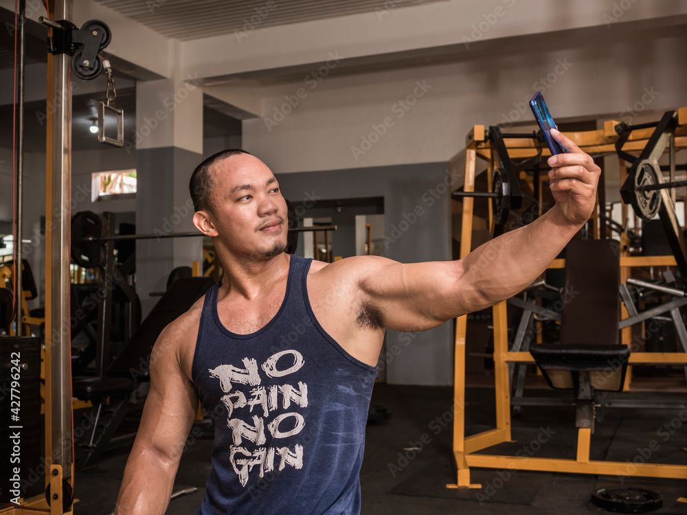 A well built and rugged man takes a selfie of himself for social media ...