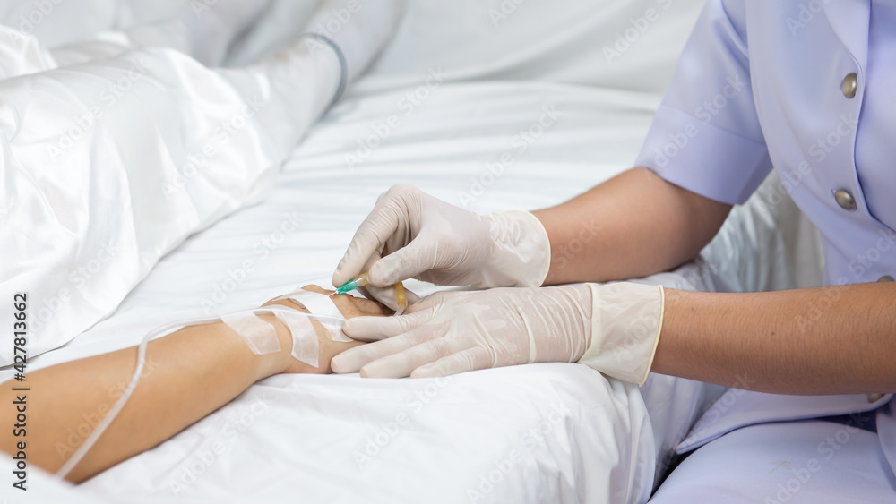 Foto de A nurse gentle injection with the medical into patient’s hand ...