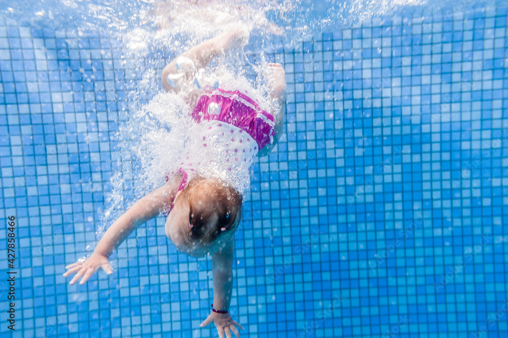 Little baby, girl swimming under water in paddling pool. Diving baby ...