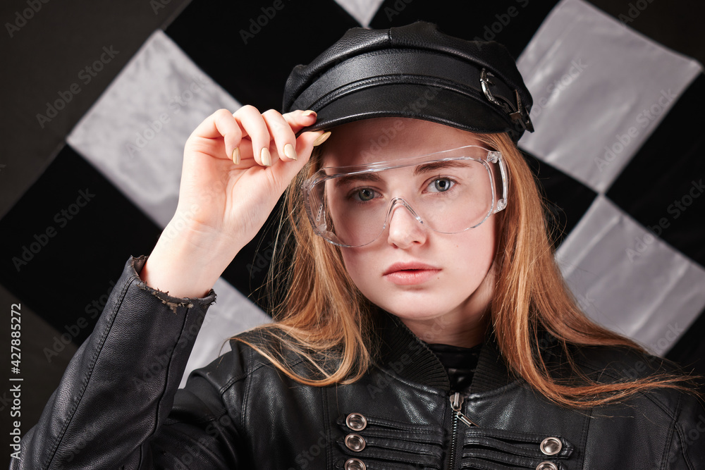 portrait of young girl in leather cap and transparent glasses ...