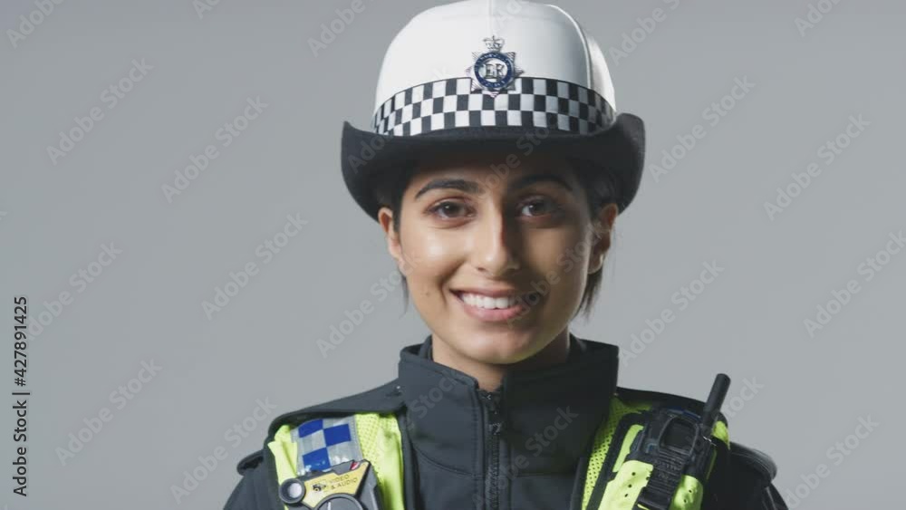 Smiling young female police office wearing uniform looking at camera in ...