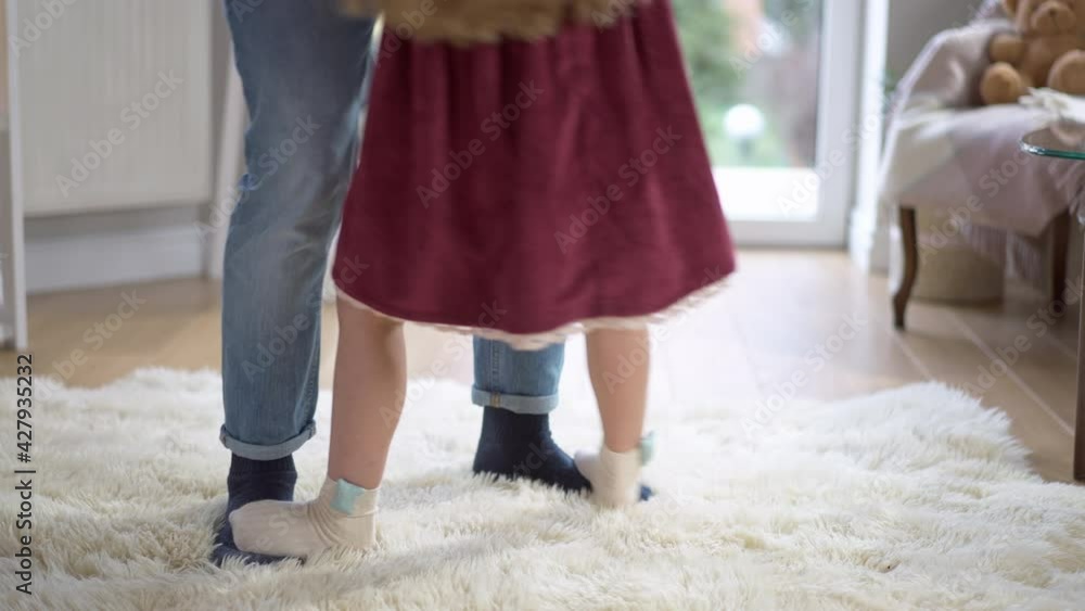 Legs of little girl stepping on man's feet and dancing. Unrecognizable ...