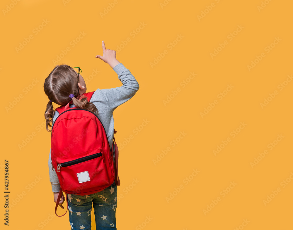 Back view of pupil in red backpack pointing up with the finger ...
