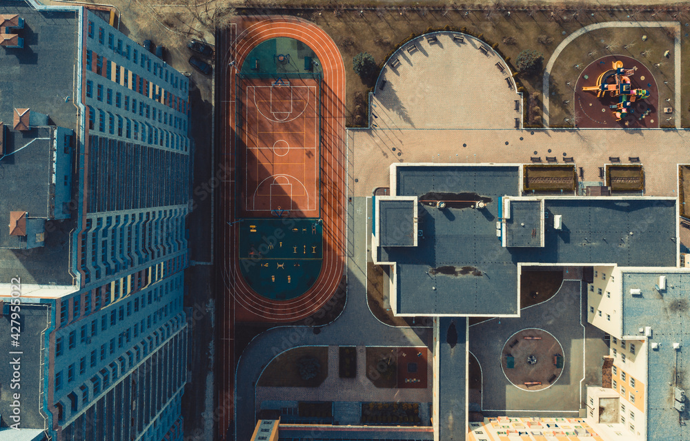 a modern school with a basketball court next to a multi-storey ...