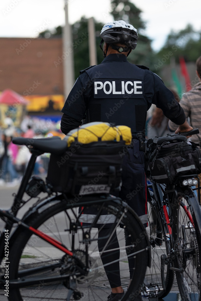 Bicycle Police officer standing next to his bike on a city street ...