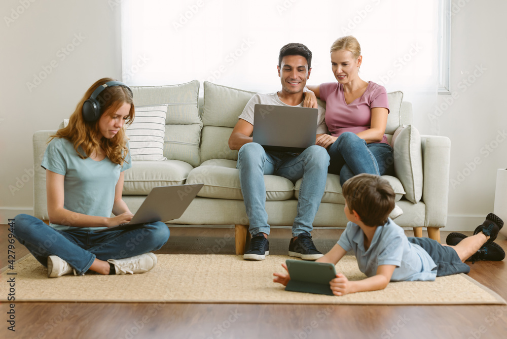 Stay at home caucasian parents working on laptops while sit on sofa and ...