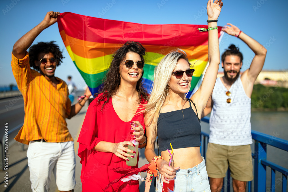 Happy group of people hanging out in the city waving LGBT with pride ...