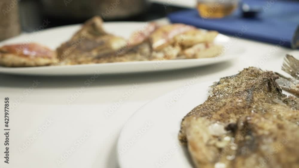 Filets of grilled boneless fish in the white plates ready to be served ...