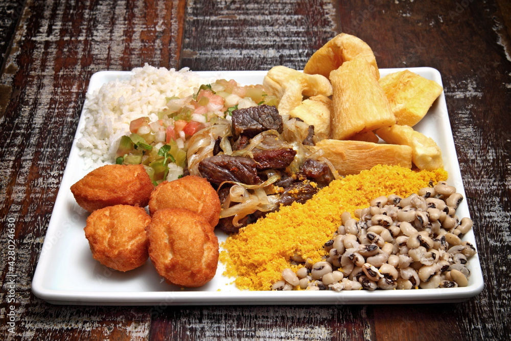 dish of Bahian food with beans, acarajé, palm oil flour, fried cassava ...