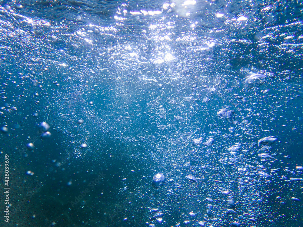 sea bubbles . Blue sea waves from underwater with bubbles. Light rays ...