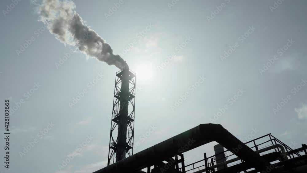 A huge oil refinery with metal structures, pipes and distillation of ...