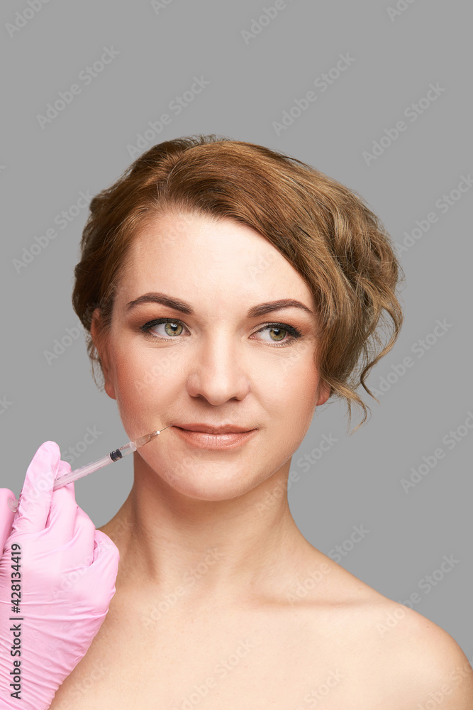 Lips injection at spa salon. Doctor hands. Pretty female patient ...