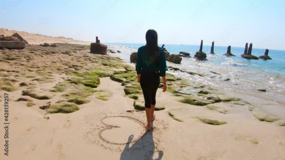 Beautiful Indian young woman walking on shore of empty beach. At ...
