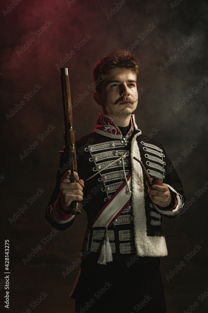 Young man in suit as royal person isolated on dark green background ...