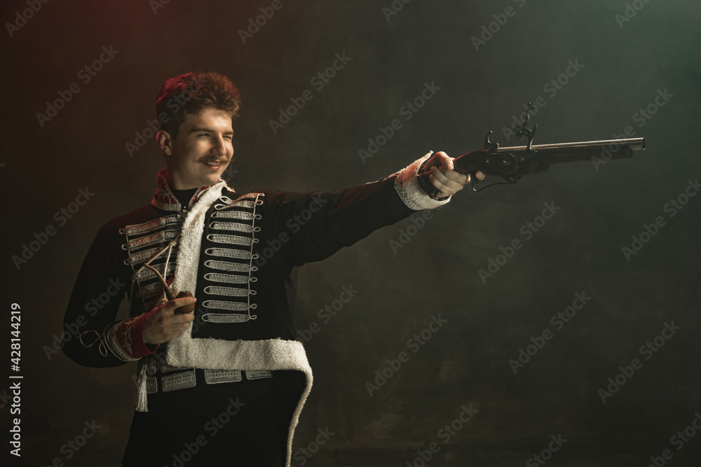 Young man in suit as royal person isolated on dark green background ...