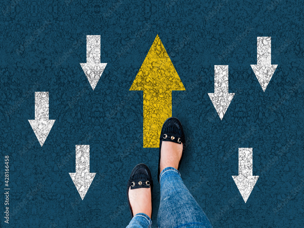 woman shoes on asphalt and opposing direction arrows on asphalt ground ...