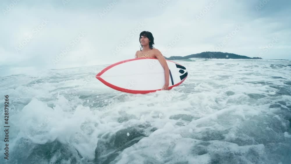 Surfer girl. Young woman surfer in bikini walks on the beach with surf ...