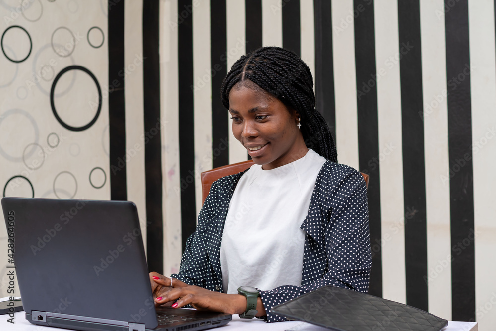 pretty african lady feeling happy as she works in the office Stock ...