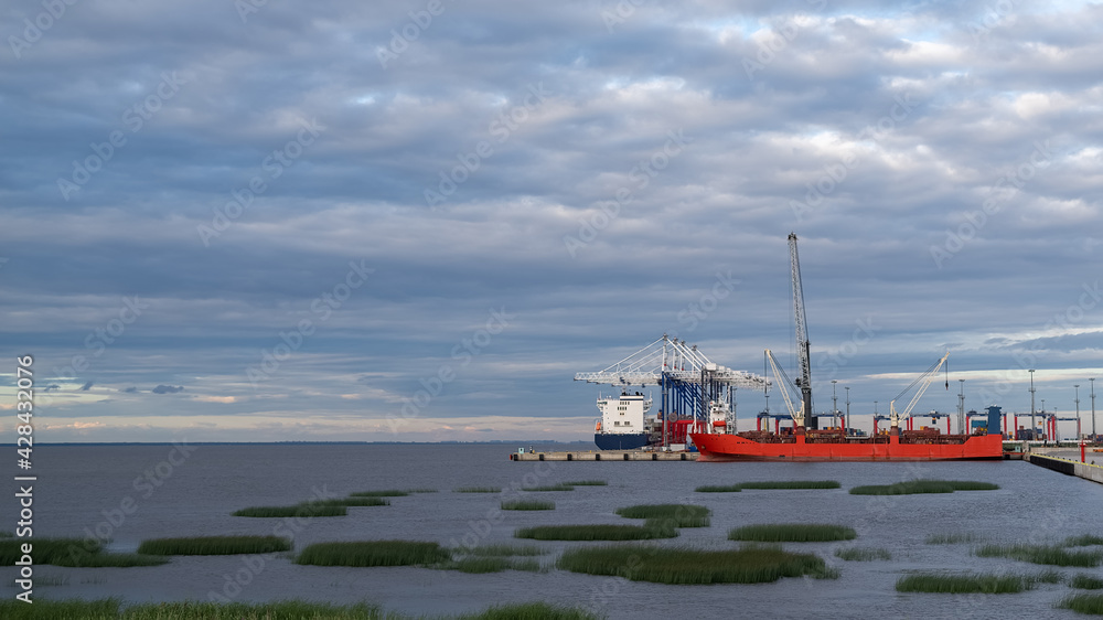 The container ship is loaded at the river cargo port. Stock Photo ...