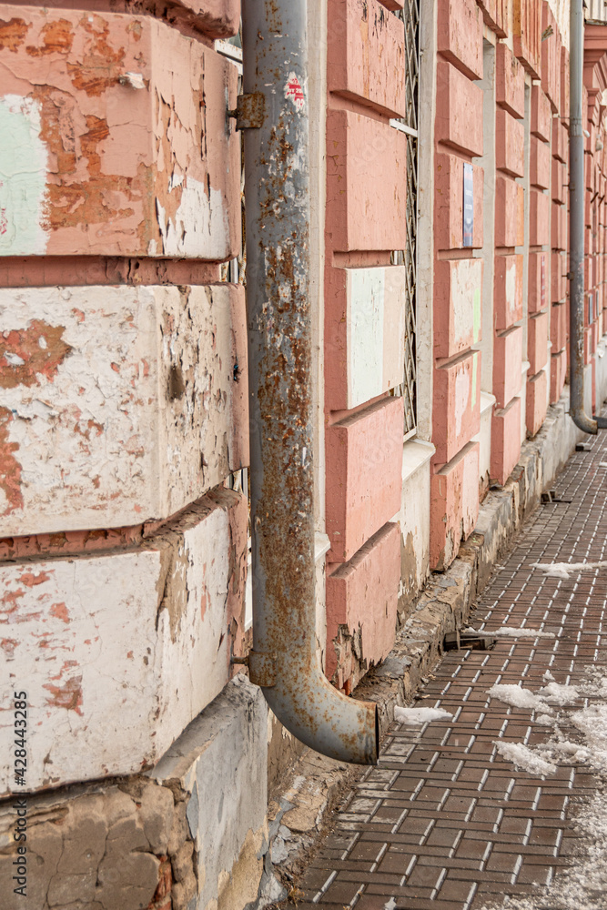 Tube against stone wall. Old gutter metal system pipe. Vertical ...
