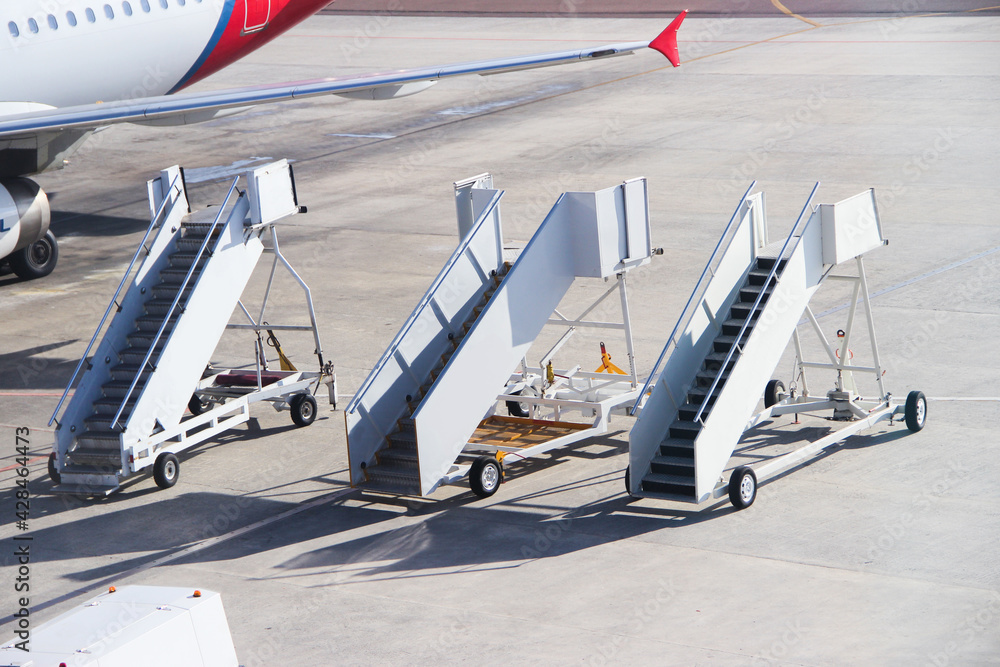 Three metal stairs for people to access the airport courtyard with ...